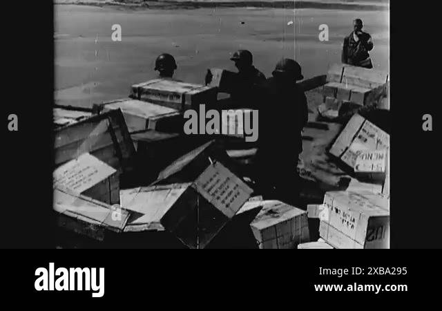 1944 - US soldiers unload rations from barge down chute to truck in ...