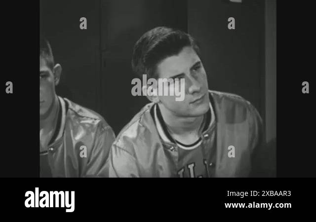 A coach gives his high school basketball team a pep talk in the locker ...