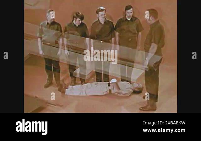 A group of men lift a man onto a stretcher in the 1980s Stock Video ...