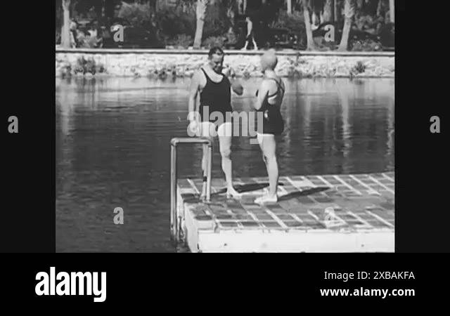 A beginning swimmer practices diving, learning the front dive, during a ...