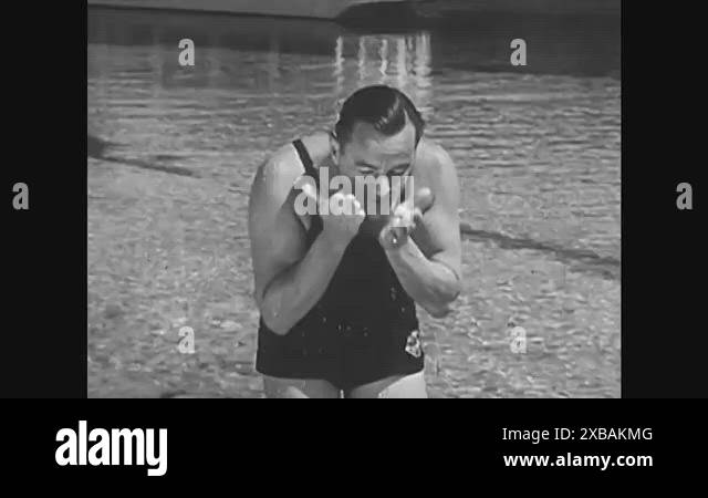 A beginning swimmer adjusts in shallow seawater, getting wet and wading ...