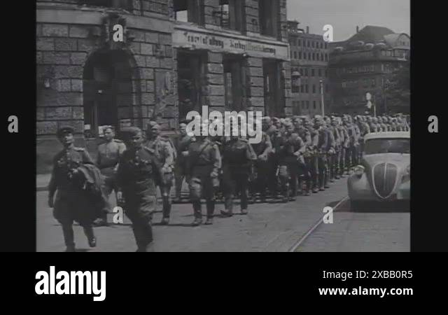 Soviet soldiers march through Berlin after WWII, taking equipment. A ...