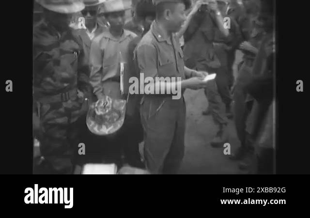 1964 - Major Vo Van Ba, Province Chief, distributes money to the heads ...