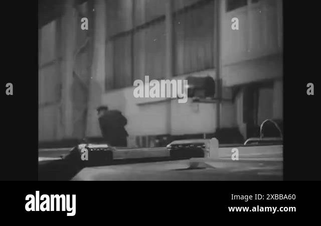 Parts of a tank are lowered into place and a tank then drives out of ...