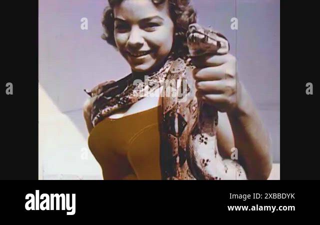 Two children, a boy and a girl, handle non-poisonous snakes that are up ...