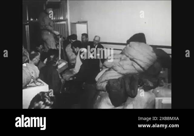 1960 Homeless civilians gather at an emergency shelter, and the US ...