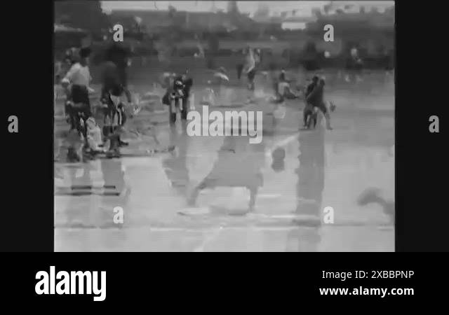 1920s, 1930s -- A group of men play a mixture of soccer, rugby, and ...