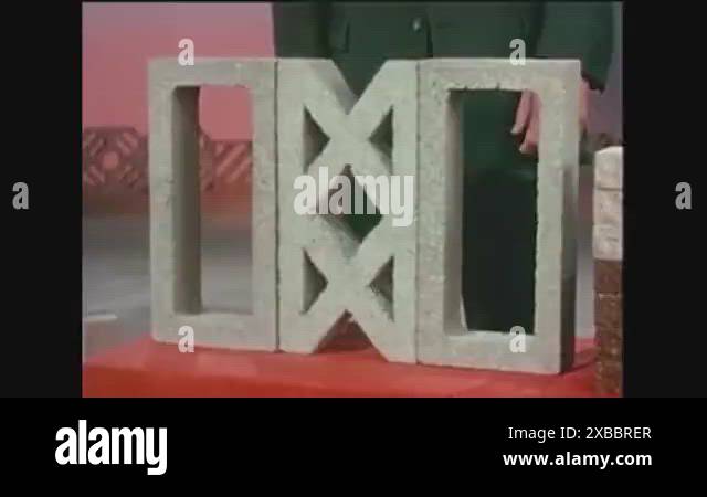 1950s -- A man showcases split block and monumental block, and ...