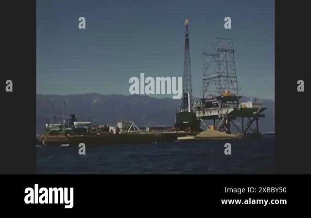 1960s Construction workers install a platform on an offshore oil rig in ...
