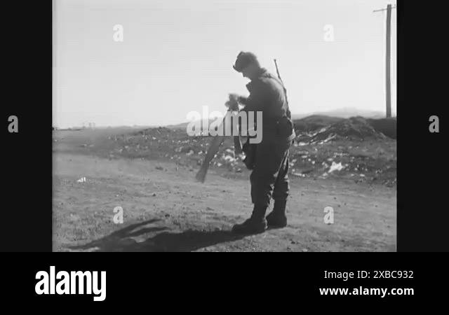 1951 - A soldier puts torn pieces of cloth on the ground, two soldiers ...
