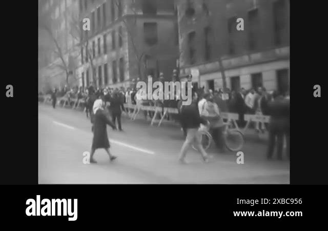 1964 - People walk on the sidewalk outside an armory at General Douglas ...