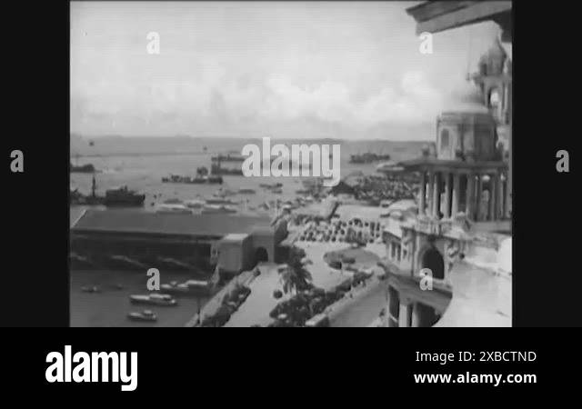 1920s - A troop transport docks, and cargo is loaded onto another ship ...