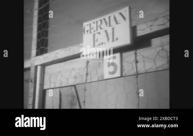 ITALY - 1945 - Prisoners of war enter a caged area, set down their ...