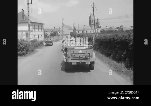 ISIGNY - 1944 - US military vehicles drive through the wrecked town of ...