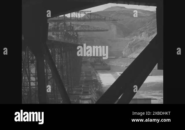 1930s - Steel mill workers are seen on beams on a mountain mill, while ...