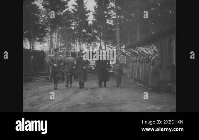Adolf Hitler walks with officers and Nazi troops walk with a tank and a ...