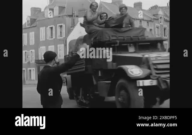 FRANCE - 1944 - Civilians wave as soldiers drive through a wrecked ...