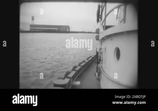 TACOMA - 1964 - A tug boat moves away from a dock, a soldier stands at ...