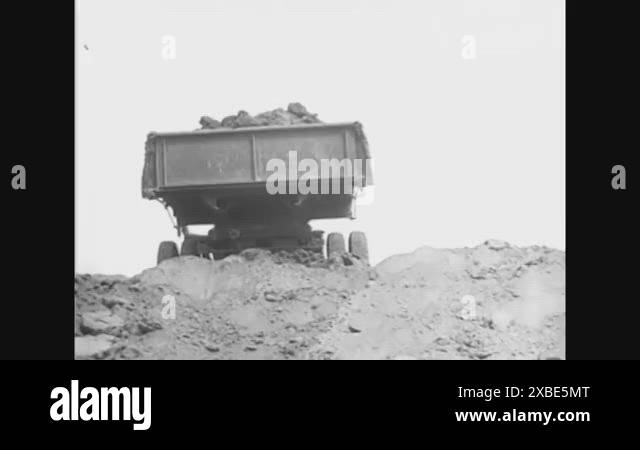 1920s - Dump trucks remove dirt from the construction site of a ...