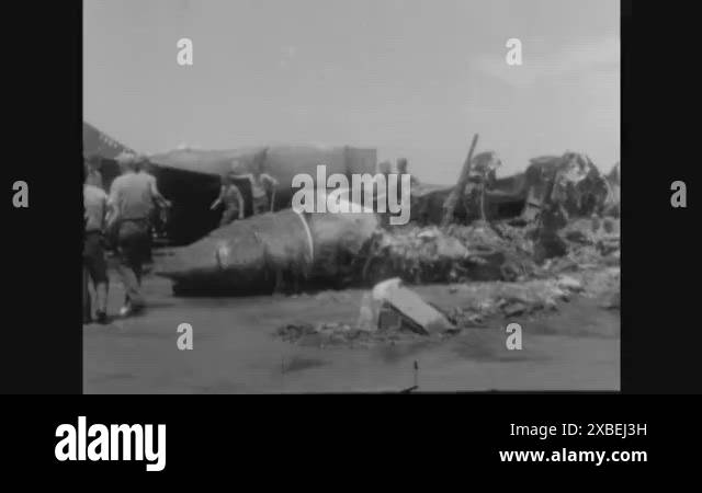 A damaged helicopter is shown and wreckage is cleared from the deck of ...