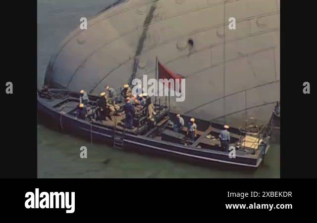 1943 - A US Navy diver is sent over the edge of a boat to hammer a ...
