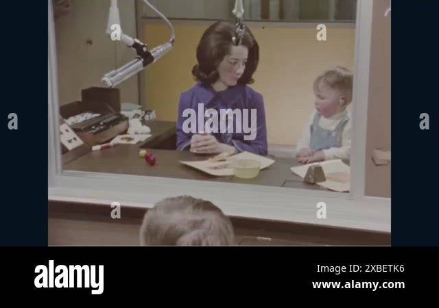 1966 - A woman conducts a behavioral audiometry test for a very young ...