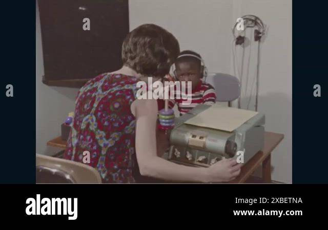 1966 - A woman conducts a behavioral audiometry test for a young boy ...