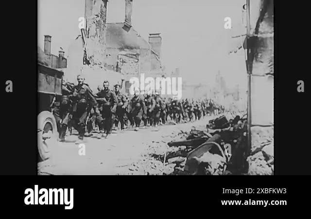 1940 - German soldiers march through the wreckage of a French city ...