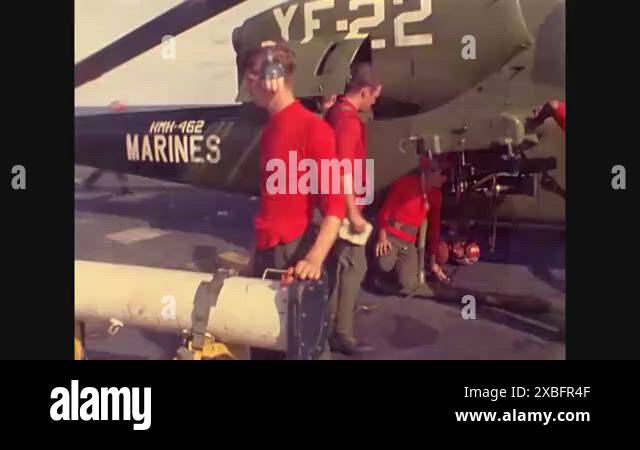 1975 - Marines load up helicopters on deck of the USS Okinawa during ...
