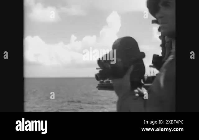 1944 - An army cameraman films as ships sit off the coast during the ...
