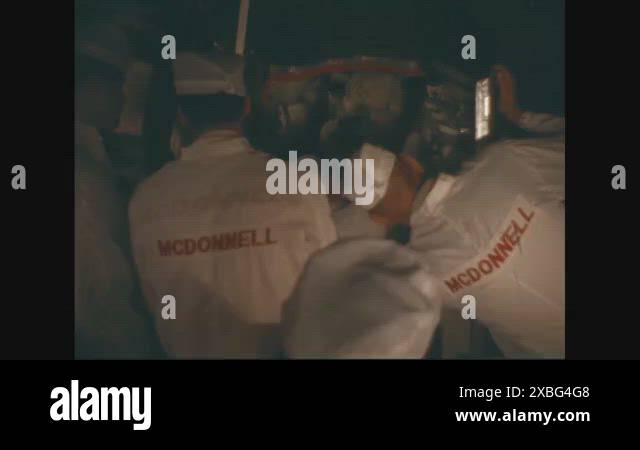 Crewmen close the hatch-doors behind an astronaut aboard the Gemini 7 ...