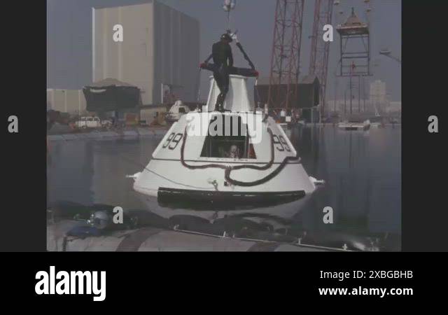 1965 - A crane pulls an Apollo command module up after a water drop ...