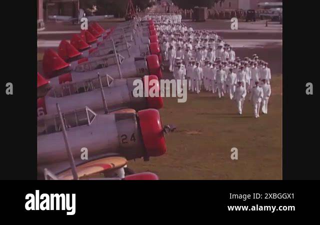 United States Navy cadets march in a formation and pose with flags and ...
