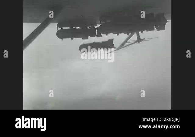 Bombs being dropped and a gunner firing 50 cal machine gun from a US ...