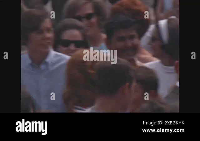 A crowd of people wait at an airport to meet the Apollo 11 astronauts ...