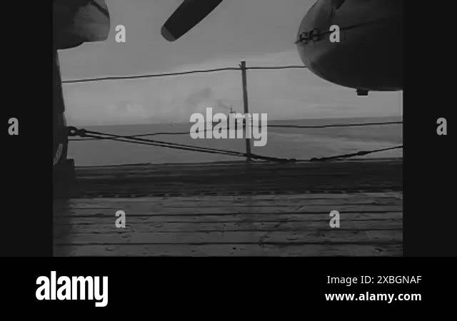 1954 - An F9F-7 plane is maneuvered onto the flight deck elevator of ...