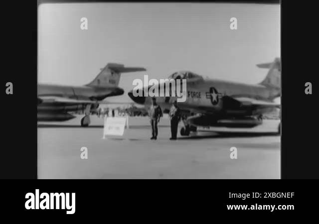 1962 - USAF pilots line up with flags and stand at attention on the ...