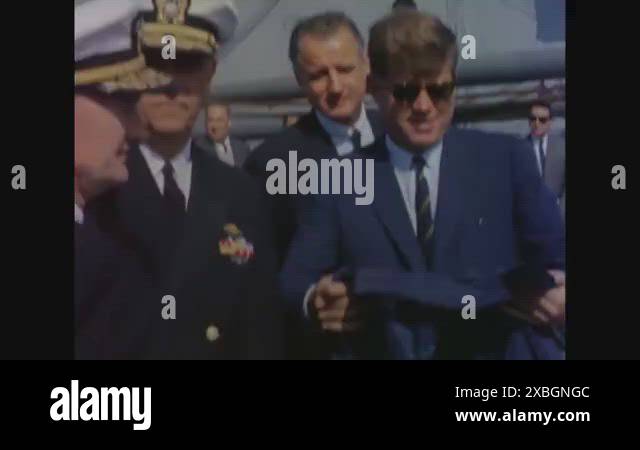 1963 - JFK is given a flight jacket and looks through binoculars on the ...