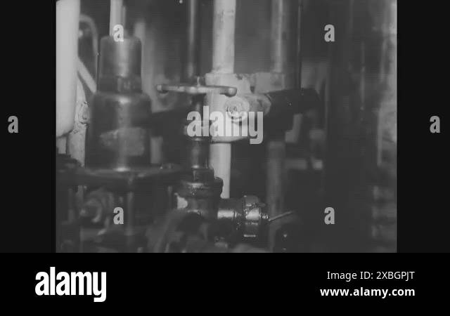 1951 - US Navy sailors work in the engine room of the USS Kidd Stock ...