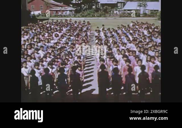 1942 - Children in a schoolyard practice putting on their gas masks ...