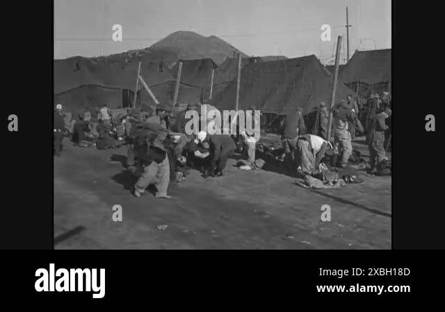 1951 - Korean POWs put on the clothing they are issued at a prison camp ...