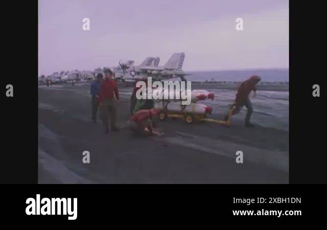 1972 - US Navy ordnance men load bombs onto planes on the flight deck ...