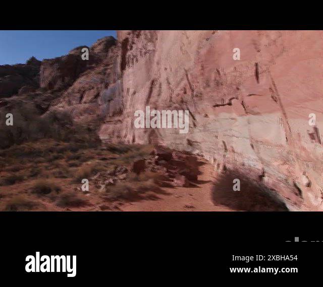 Pan-right slowly across the face of a remote canyon cliff with American ...
