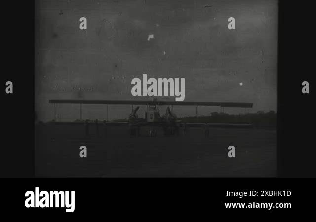 A gunner aims a machine gun aboard a French biplane and a pilot is ...
