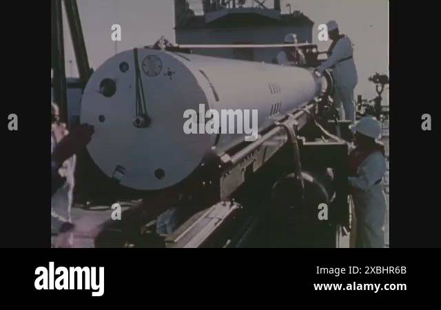 1960s - US Navy sailors prepare a missile for launch. The camera goes ...