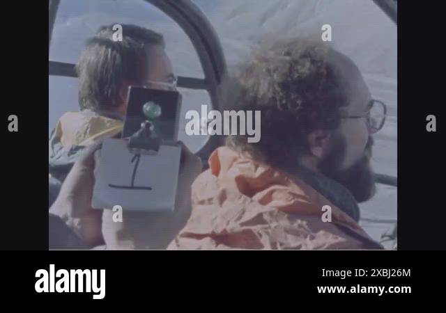 1980s - Scientists talk animatedly in an aircraft as it flies towards ...