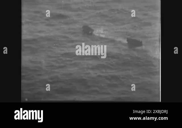 1940s - Aerial footage shows rescue vessels approaching a sinking ship ...