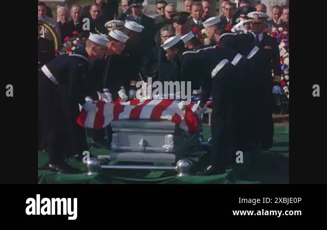 1967 - US Navy sailors hold an American flag over Roger Chaffee's ...