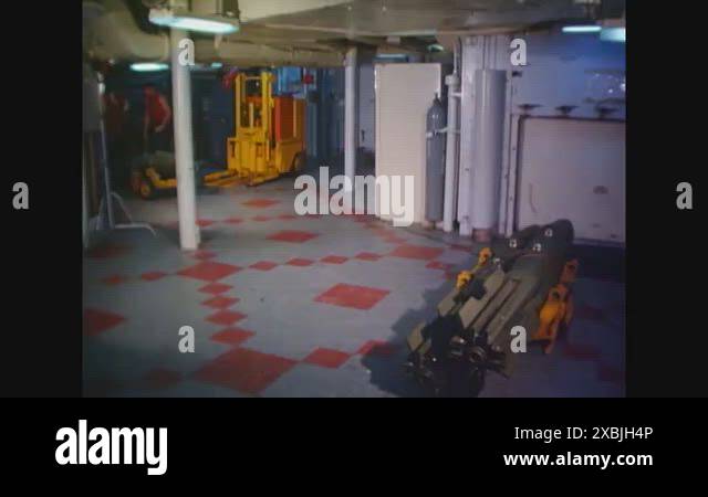 1967 - Below deck on the USS Constellation, US Navy seamen wheel bombs ...
