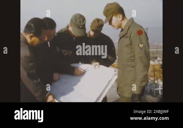 1968 - American soldiers and Korean construction workers go over ...